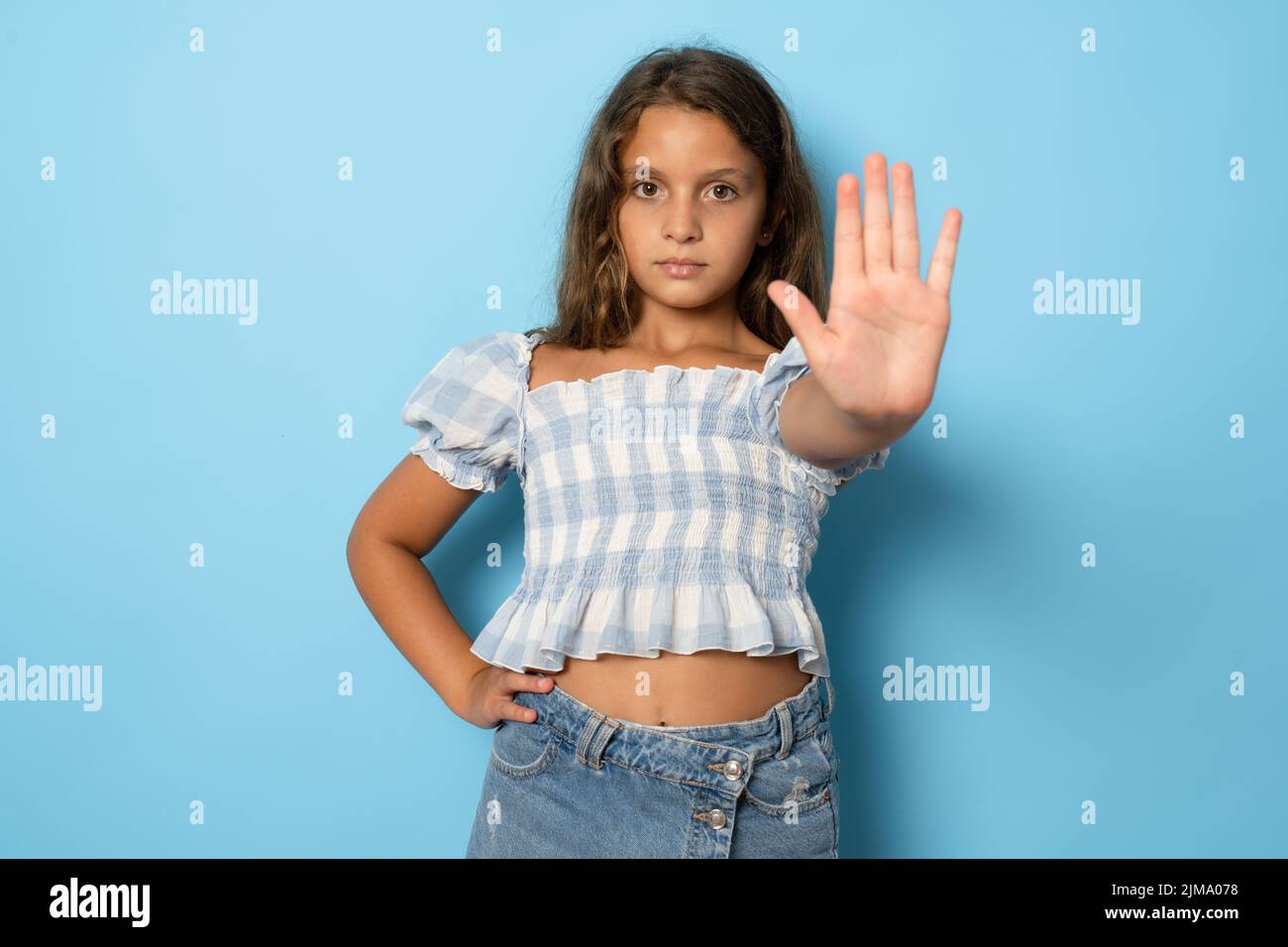 Full body little girl serious and determined, putting hand in front ...