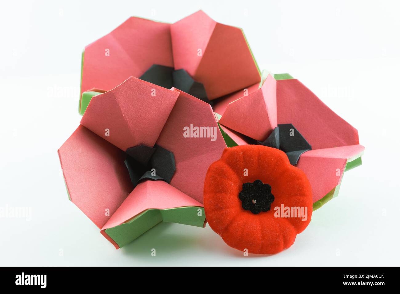 Three red origami poppies on a white background with a red velvet poppy ...