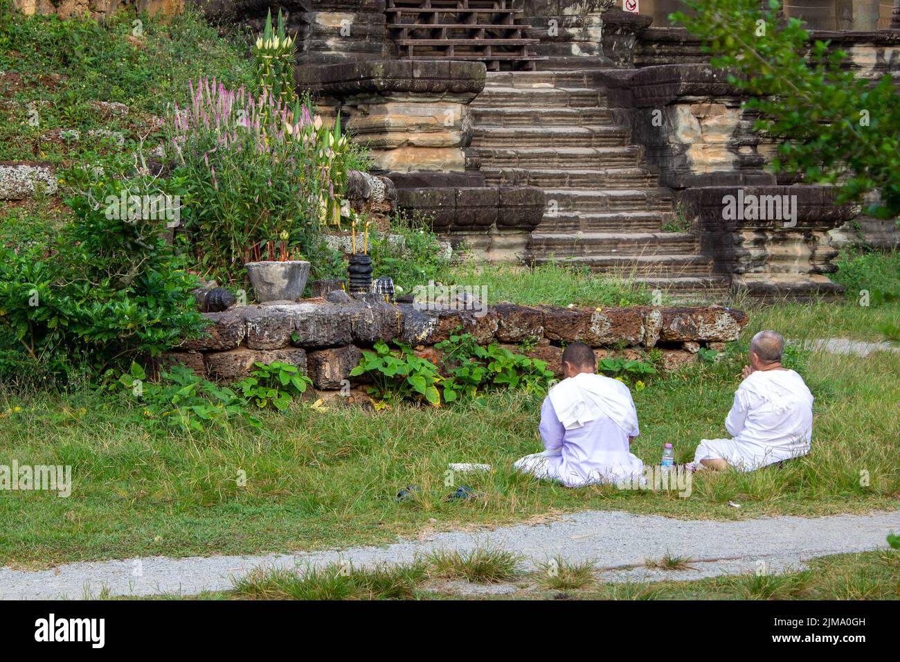 Buddhist monks sitting on the grass in front of the stairs of the ...