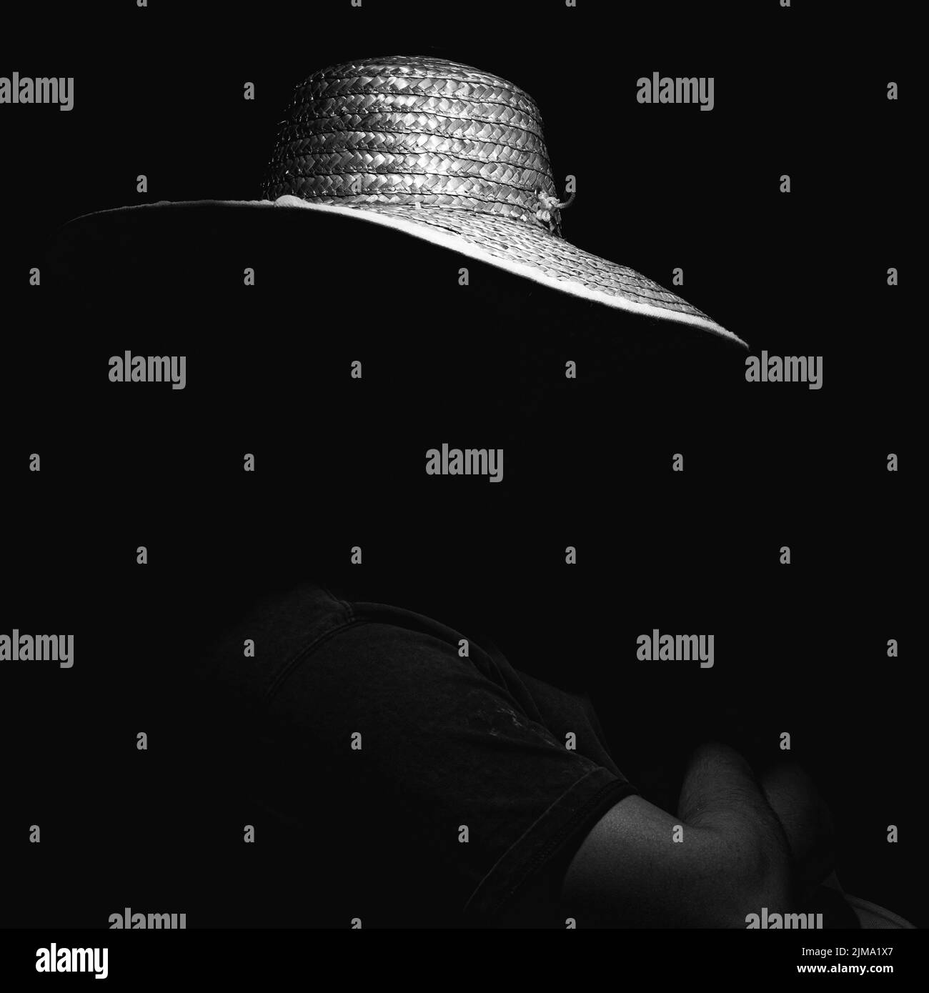 A portrait of a mysterious man with a hidden face wearing a boater hat ...