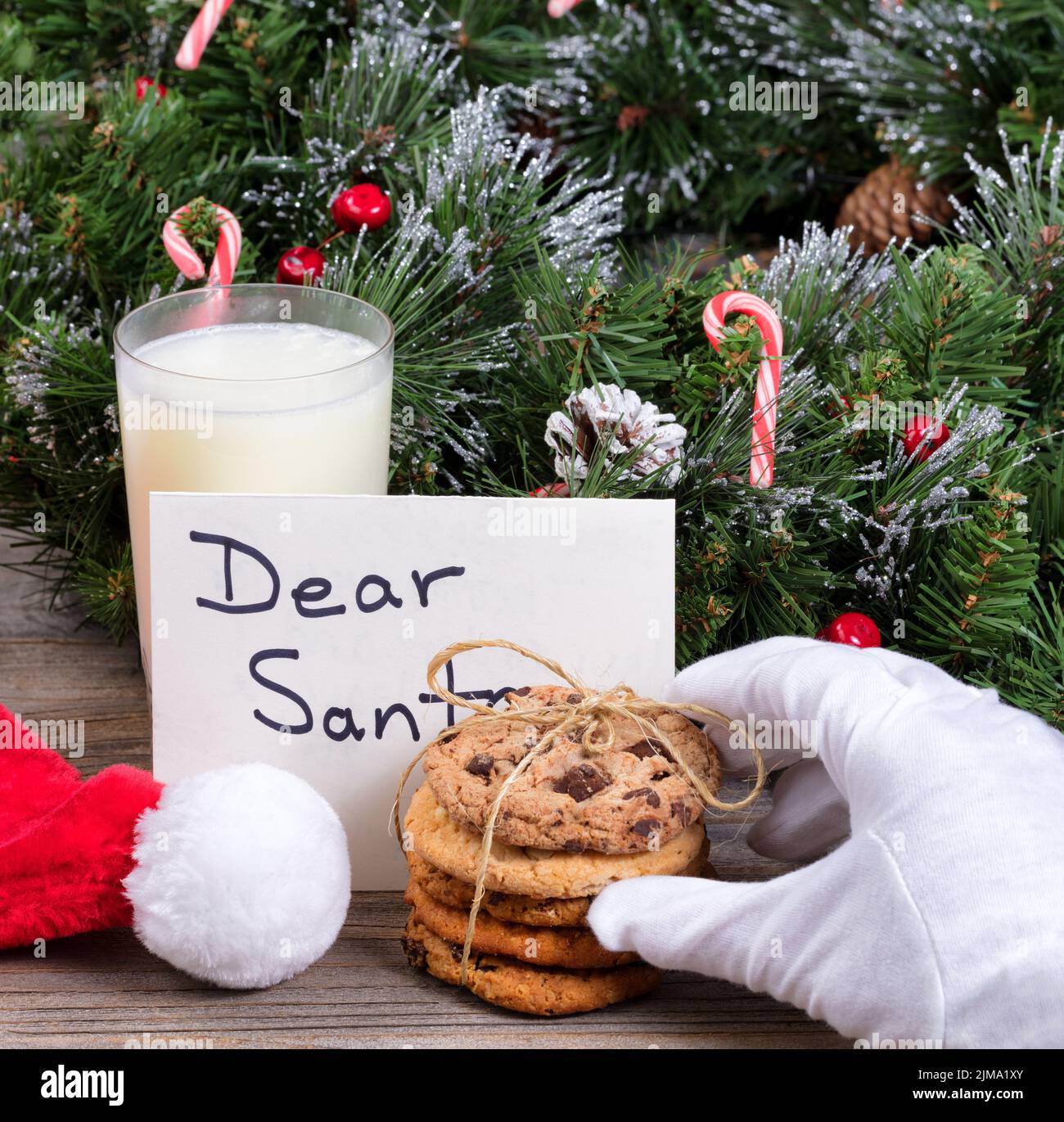 Santa Claus hand reaching for a cookie with holiday decorations and ...