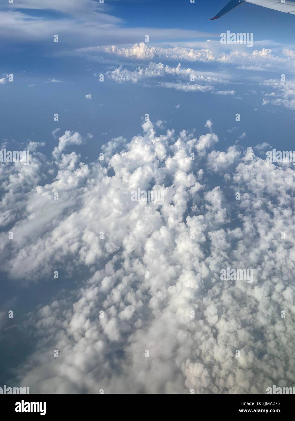A vertical shot of fluffy clouds. View from inside a plane Stock Photo ...