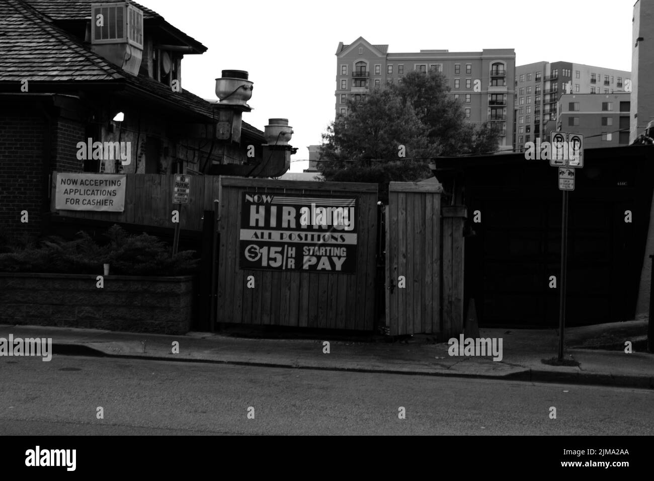 A grayscale of help wanted signs posted on a wooden fence in Nashville ...