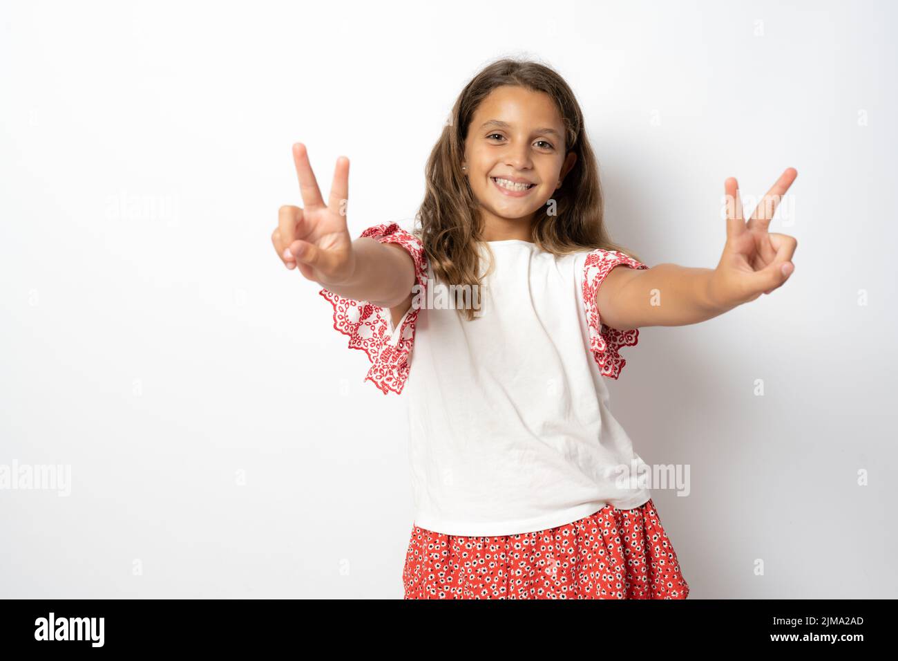 kid giving peace symbol with fingers standing isolated over white ...