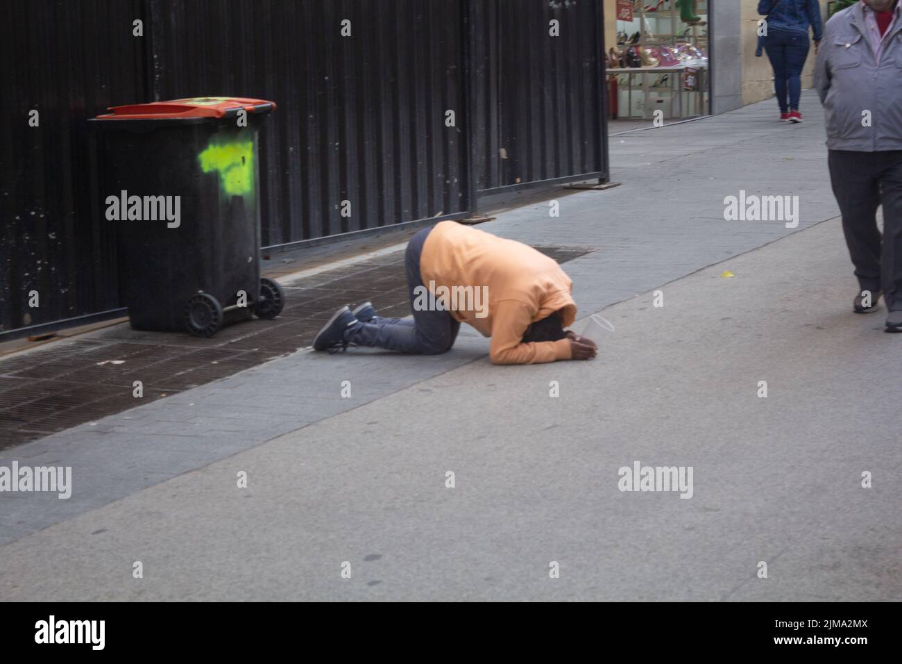 A poor person asking for alms in the streets of Madrid in posture of ...