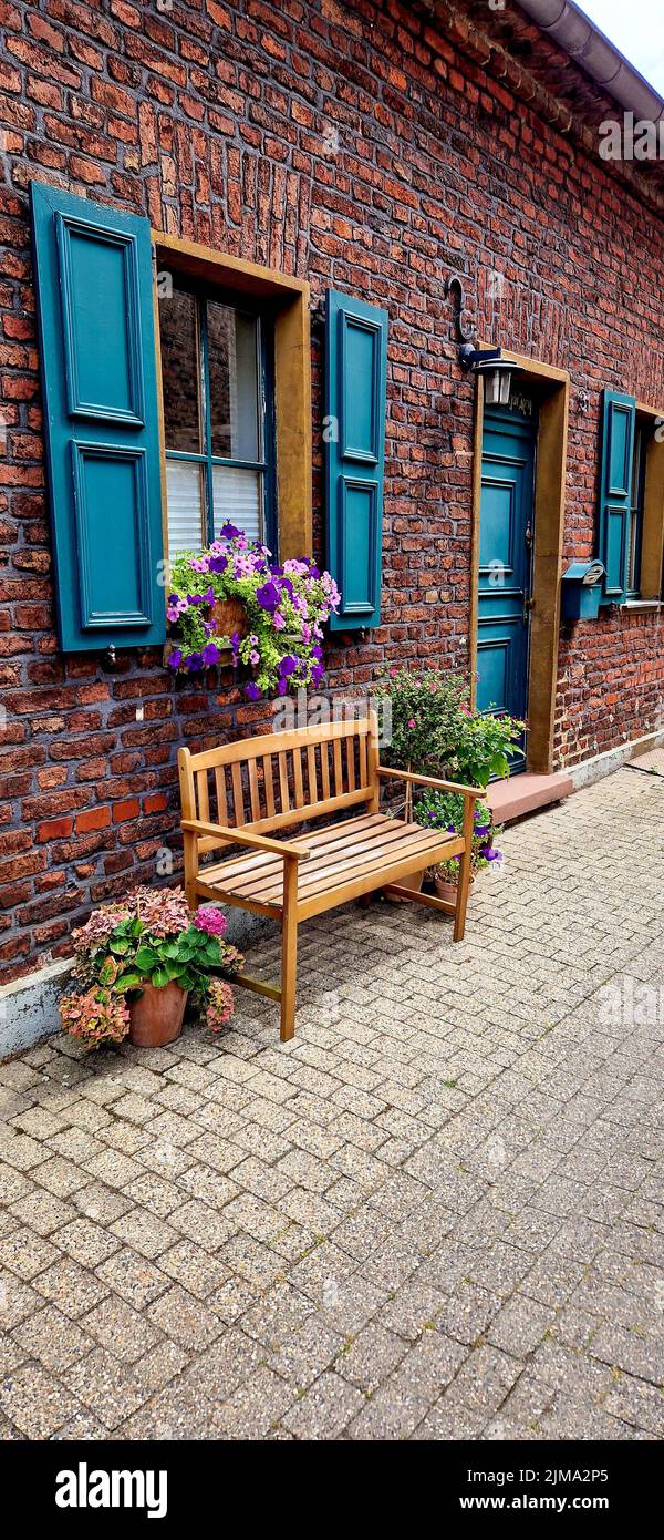 A bench in front of a house with blue windows Stock Photo - Alamy