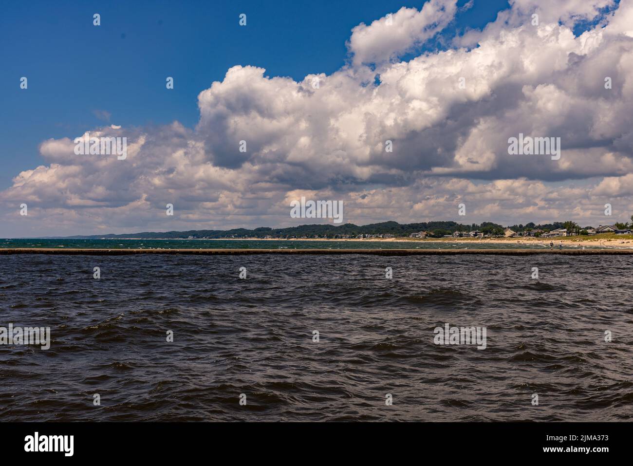 Lake Michigan coast beach as seen from the water with large clouds ...