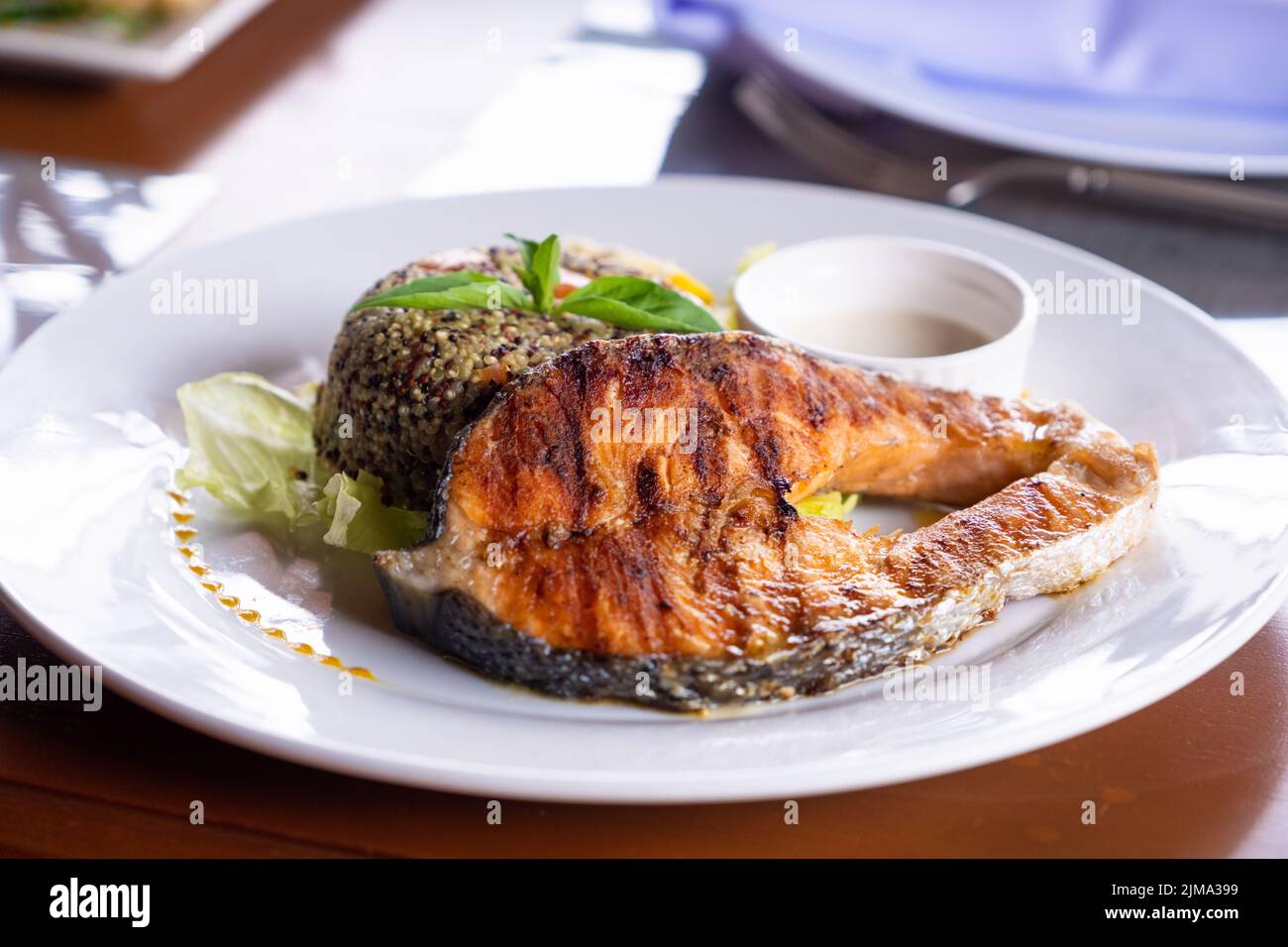 The close-up high-angle view of a grilled fish with cooked quinoa on ...