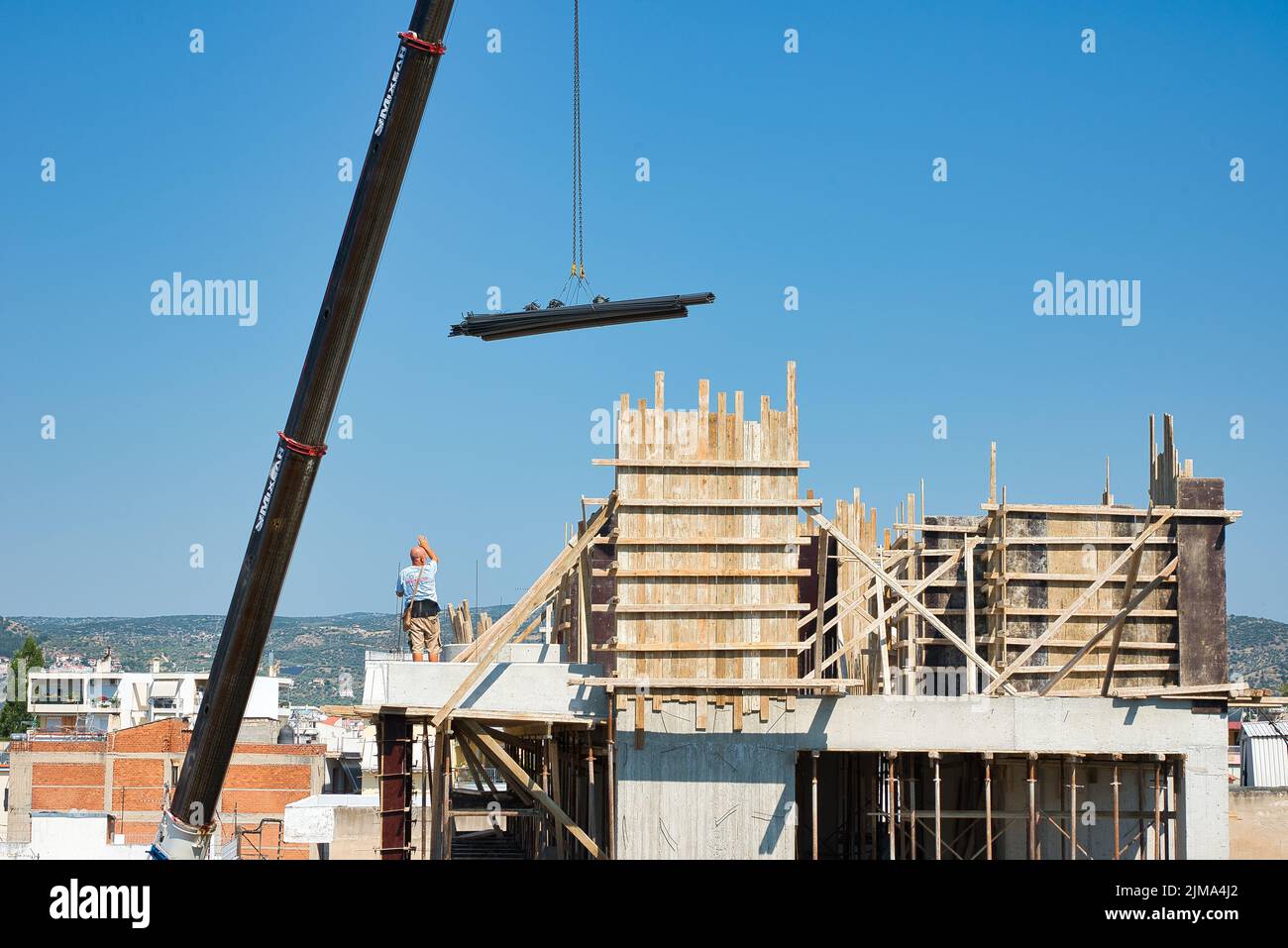 heavy-duty self-propelled crane unloads iron materials in an erected ...