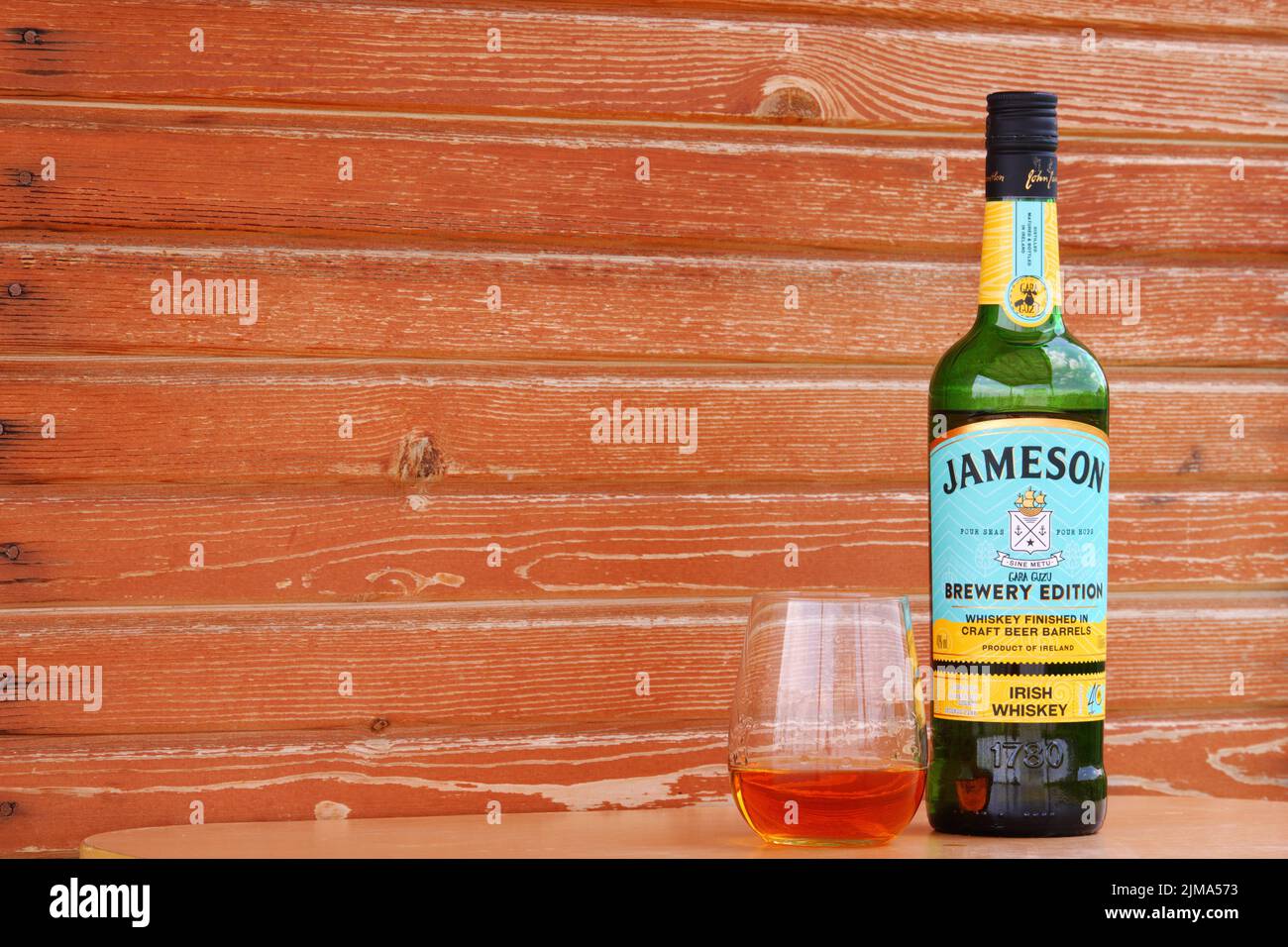 Whiskey bottle and glass with wooden background Stock Photo - Alamy
