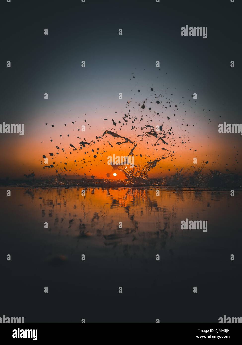 A vertical shot of sea wave splash with reflection against a scenic ...