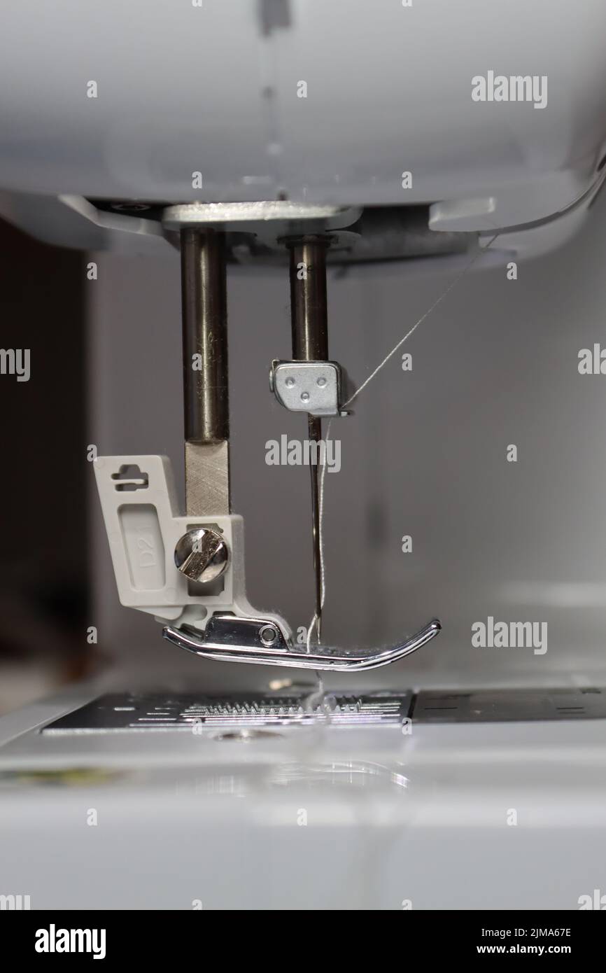a sewing machine foot with needle and sewing plate Stock Photo - Alamy