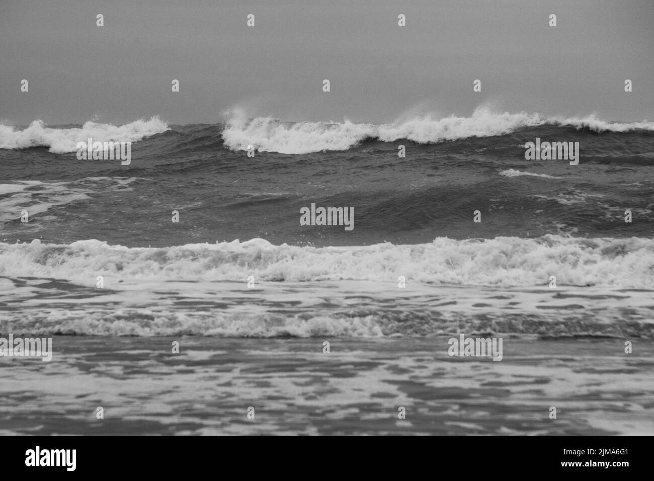 A scenic grayscale shot of sea waves washing the shore Stock Photo - Alamy
