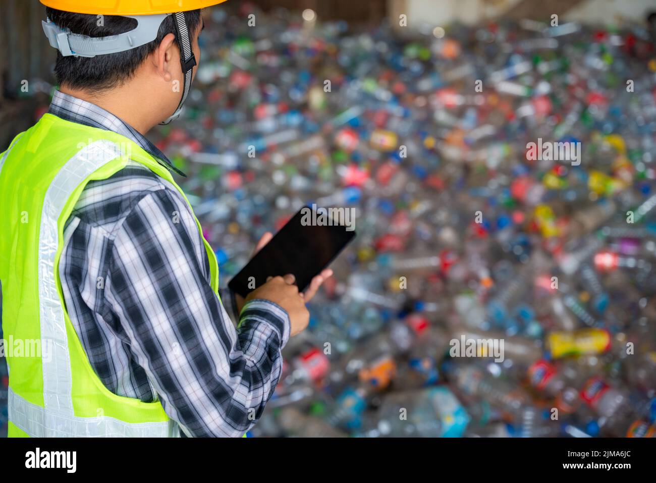 A recycling Analyst looking at plastic bottle ofr recycling waste To ...
