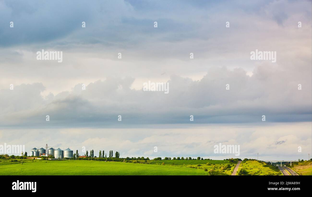 Farm silos at a distant farm at sunset Stock Photo - Alamy