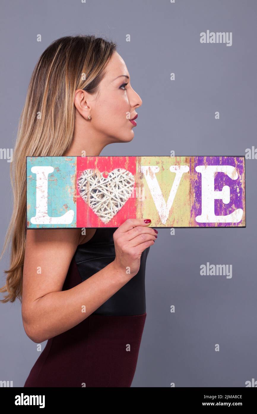 Woman wearing red dress holding sign love symbol Stock Photo - Alamy