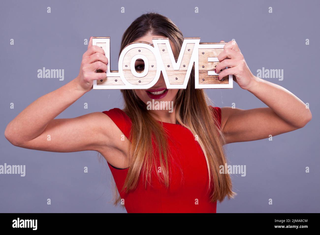 Woman wearing red dress holding sign love symbol Stock Photo - Alamy