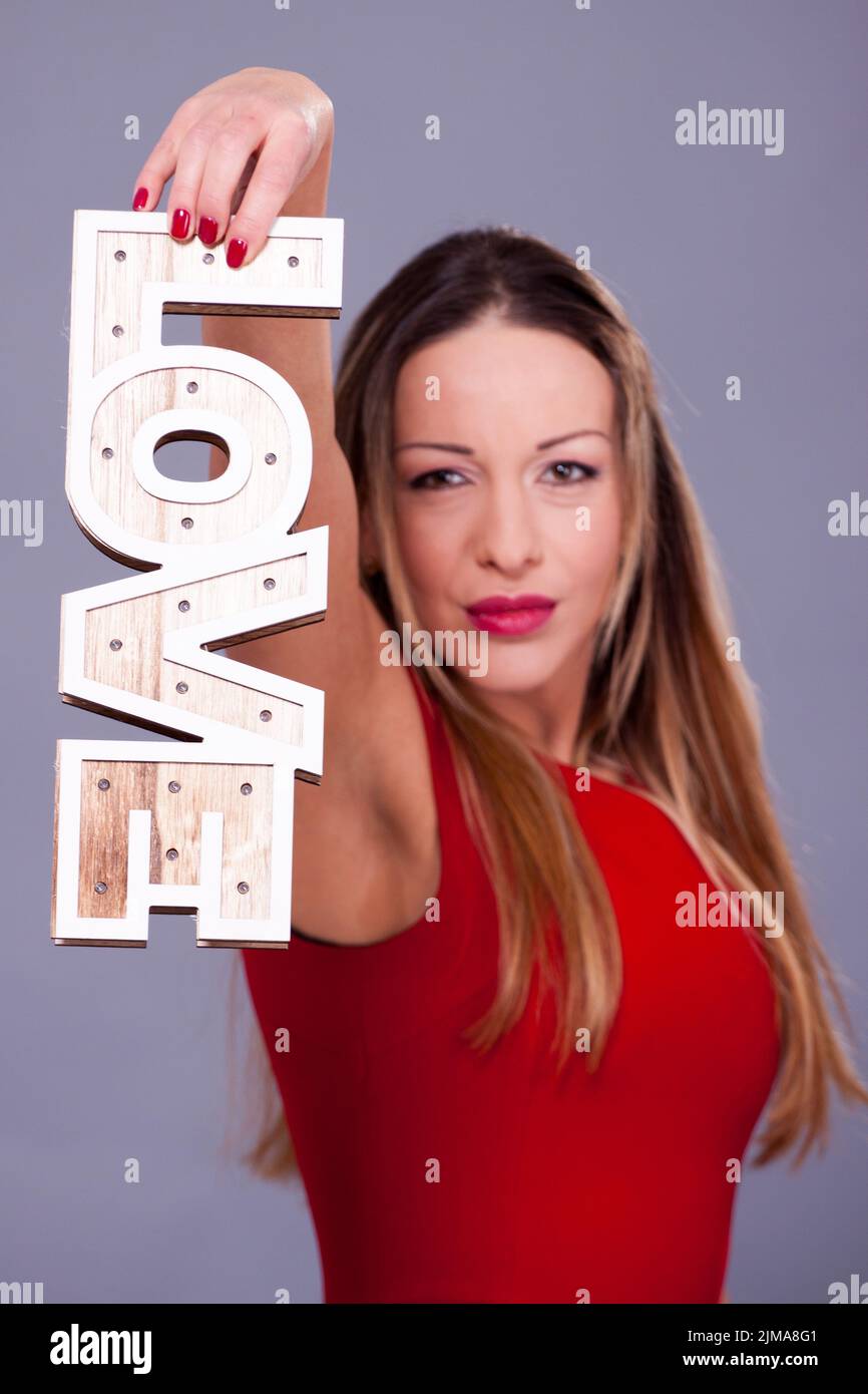 Woman wearing red dress holding sign love symbol Stock Photo - Alamy