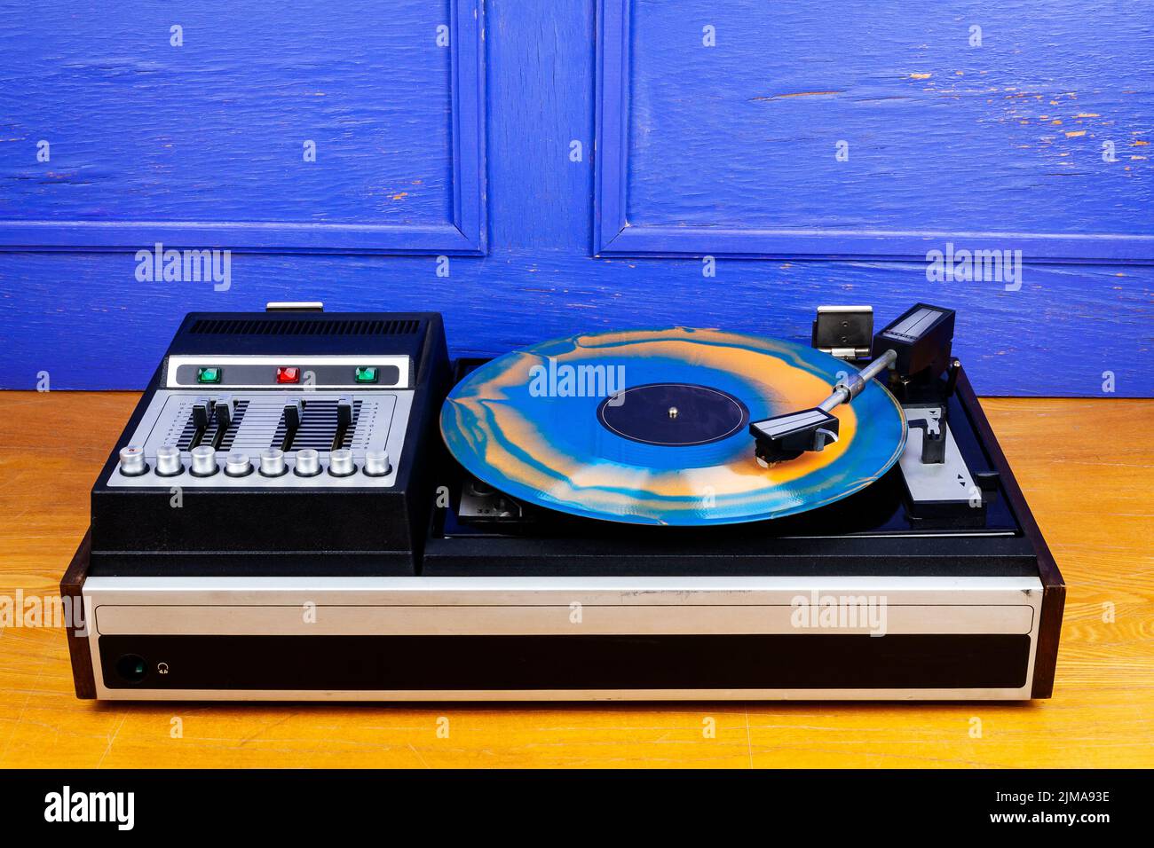 Vintage turntable vinyl record player with blue and orange vinyl on a ...