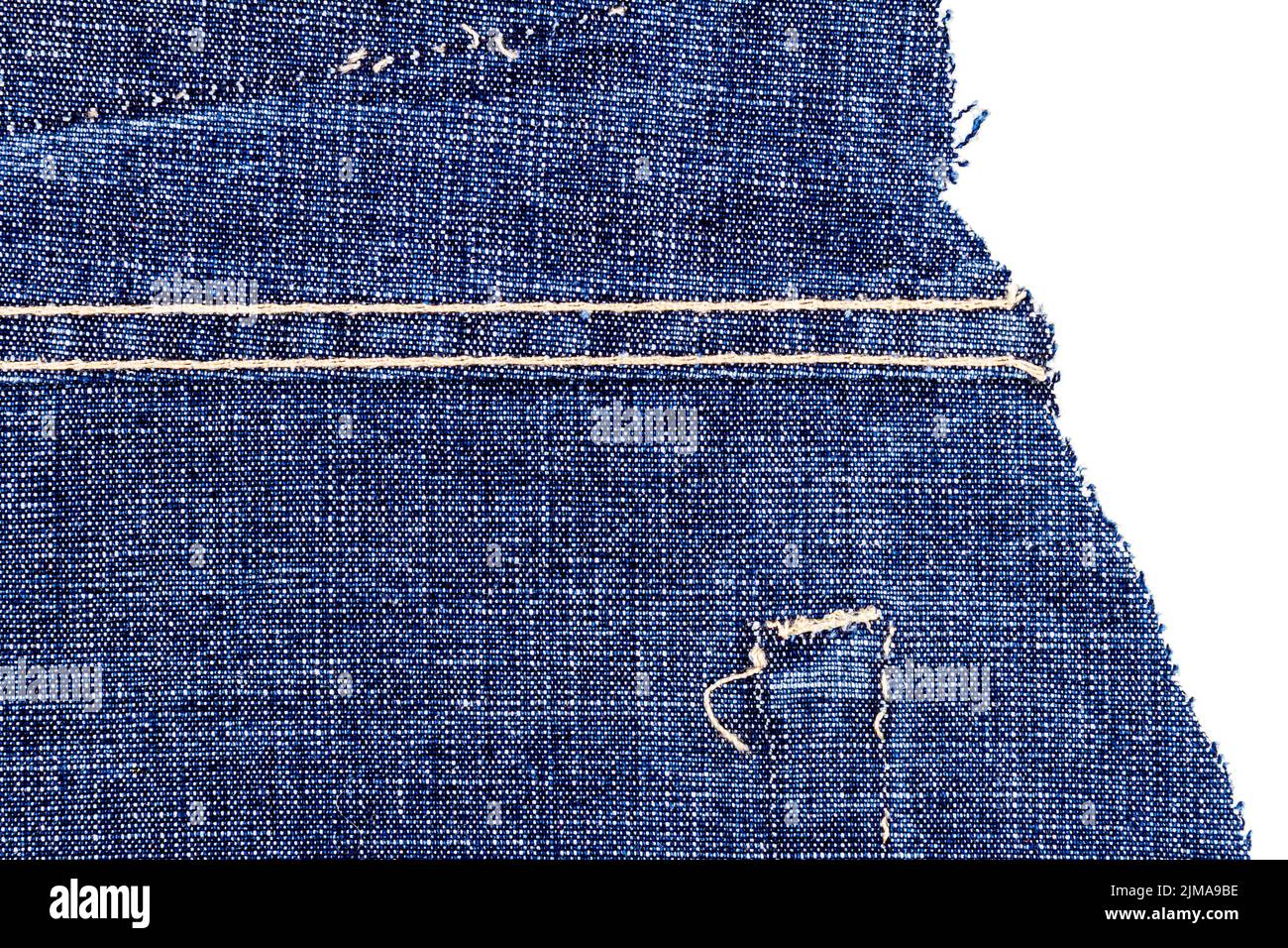 Piece of blue jeans fabric with a ripped of back pocket isolated on ...