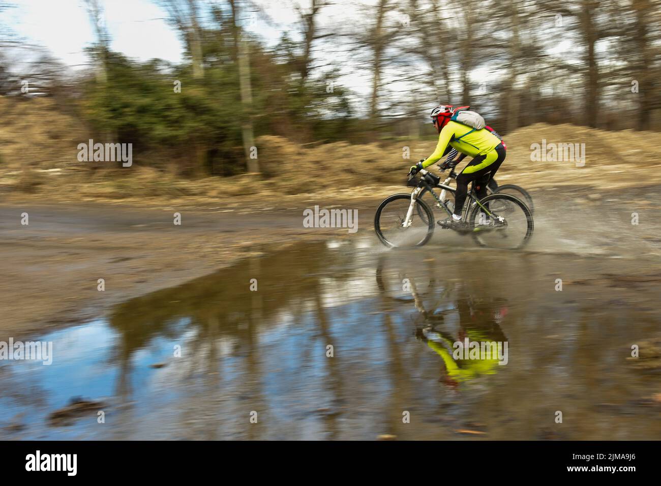 Cyclist crosses a stream with his bike and churns up the water Stock ...
