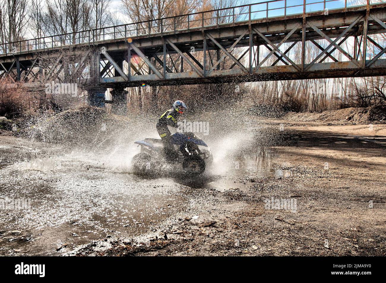 Quad ride along the river with a splash of water Stock Photo - Alamy
