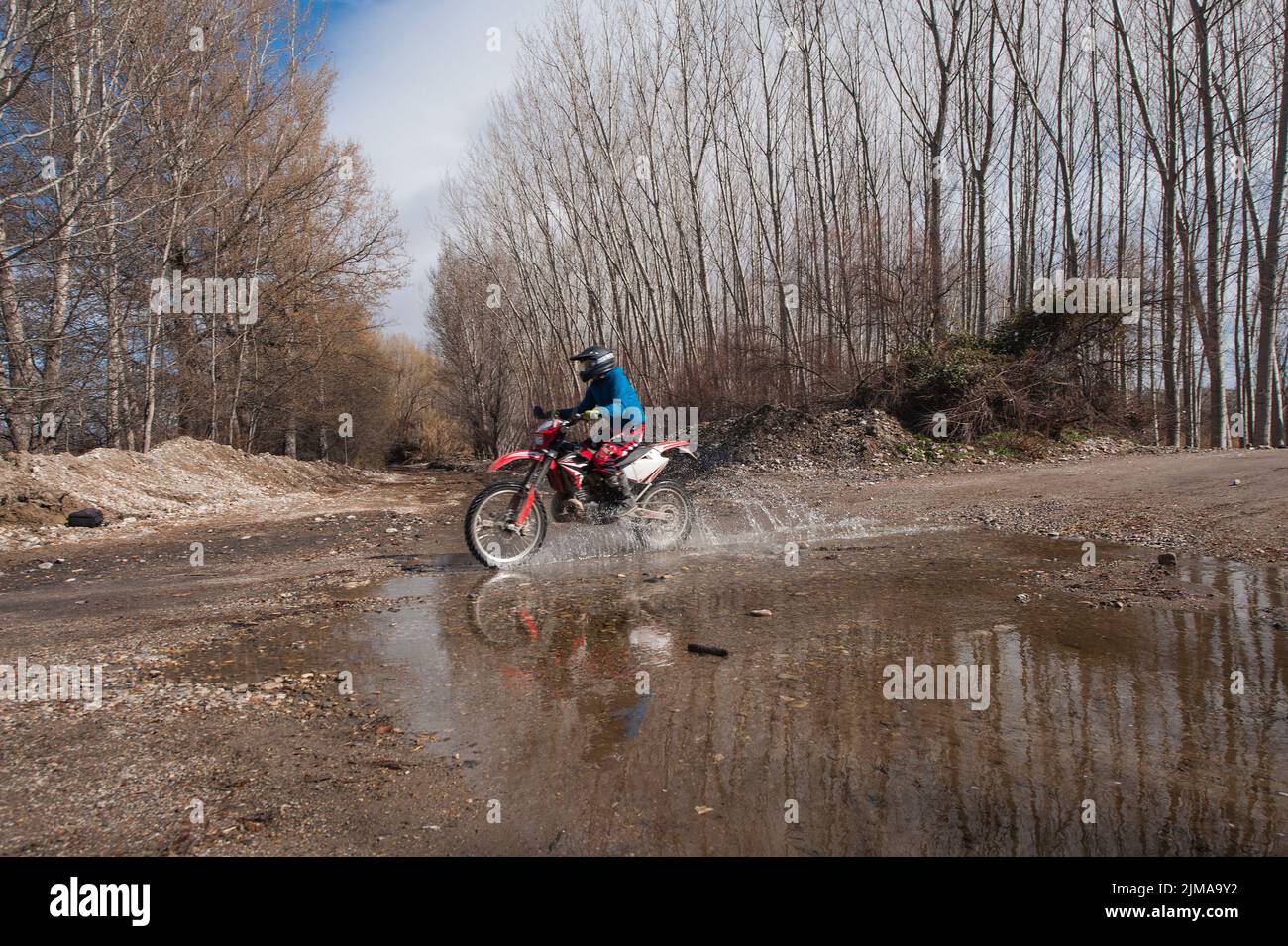 Motorcycle ride along the river with a splash of water Stock Photo - Alamy