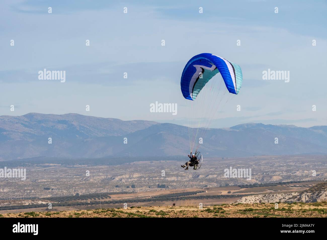 Flying with paramotor in the air on blue sky background Stock Photo - Alamy