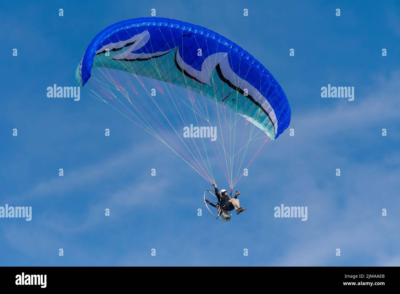 Flying with paramotor in the air on blue sky background Stock Photo - Alamy