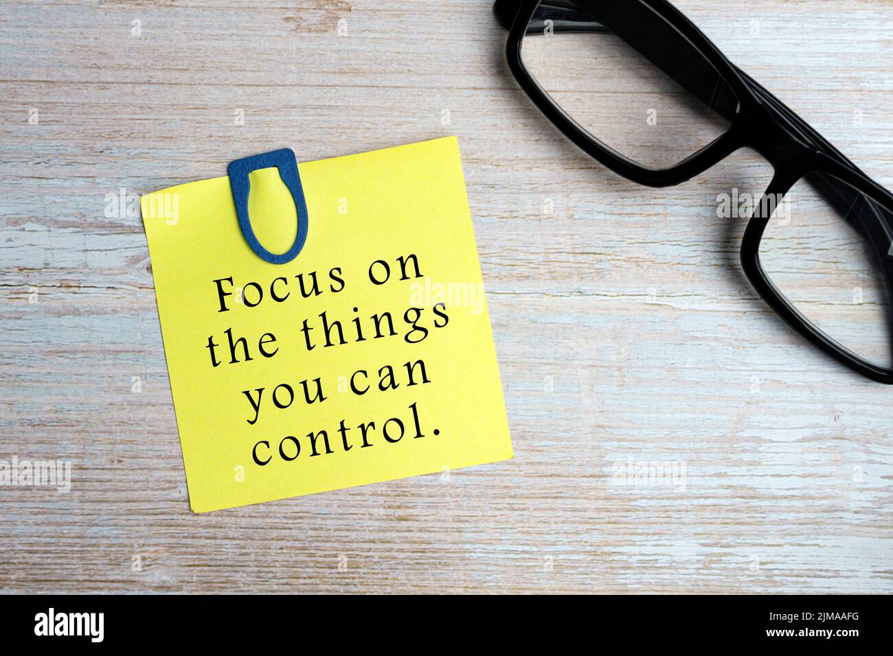 Motivational quote on sticky yellow note on wooden desk - Focus on the ...