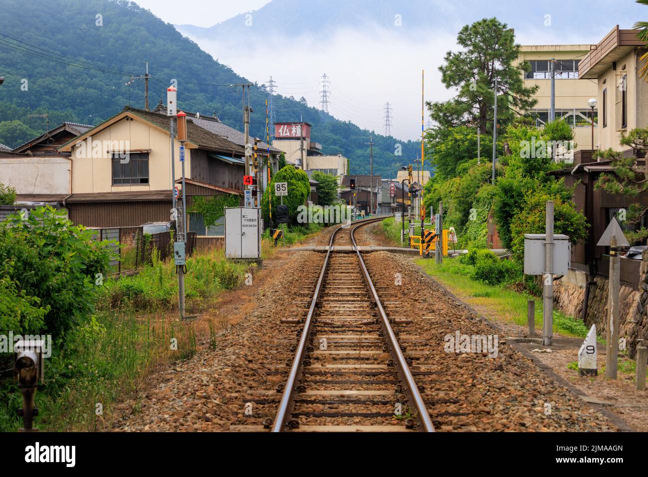 Railroad track through small Japanese mountain town as morning fog ...