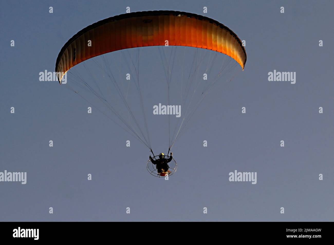 Flying with paramotor in the air on blue sky background Stock Photo - Alamy
