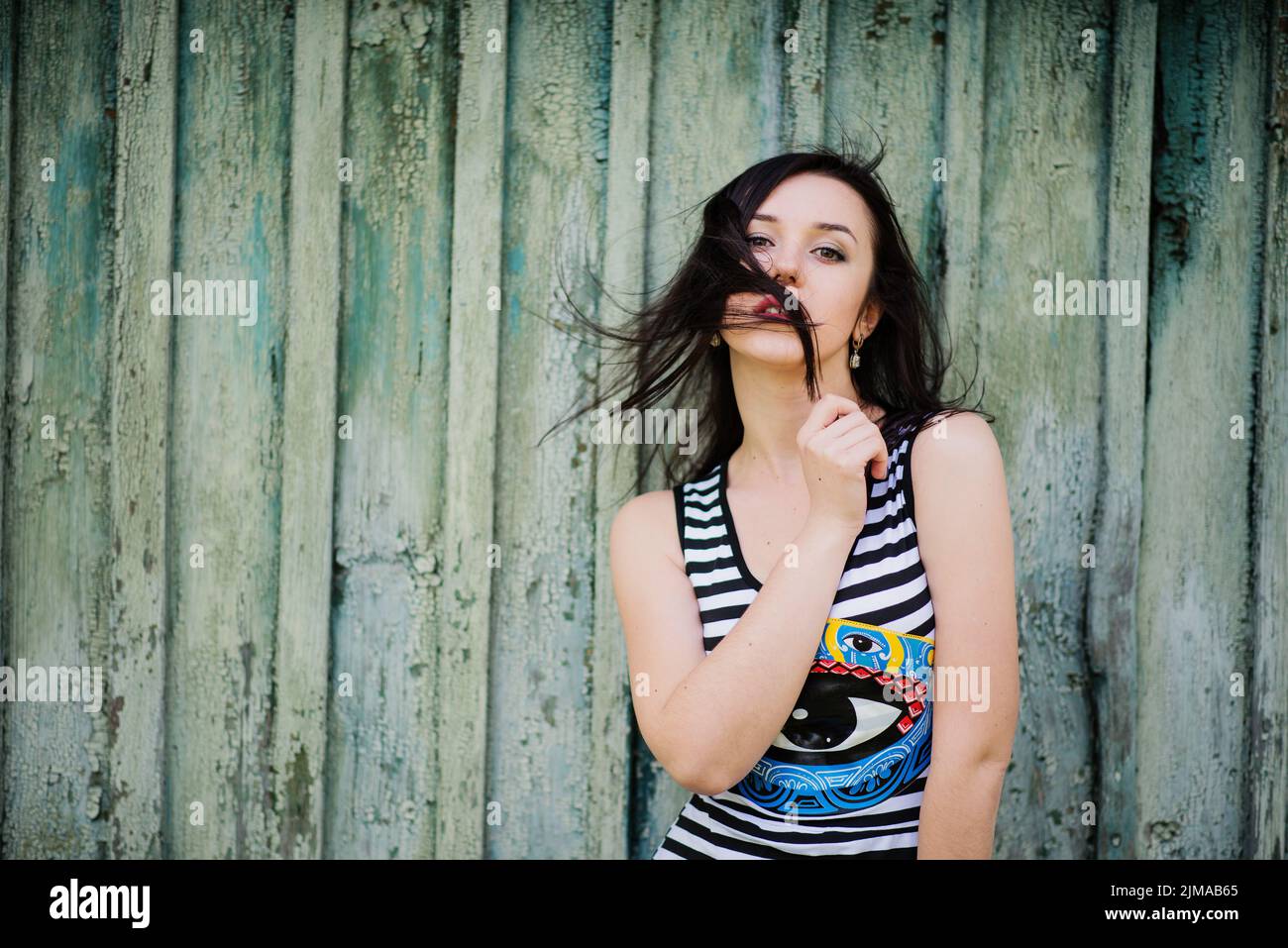 Brunette Model Girl At Dress With Stripes Background Cian Wooden