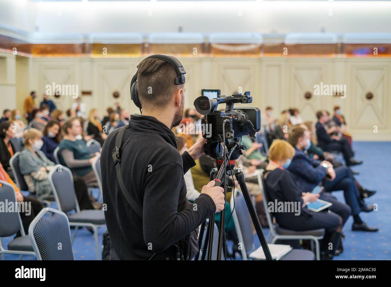 Cameraman shooting speakers during business conference Stock Photo - Alamy