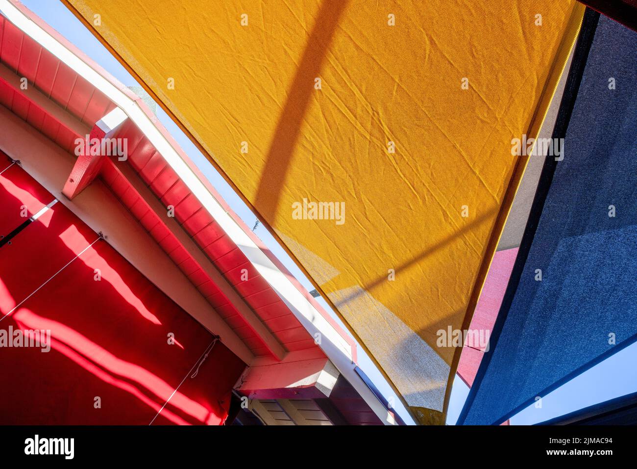 Colorful stretched sails shine in the sun and provide shade Stock Photo ...