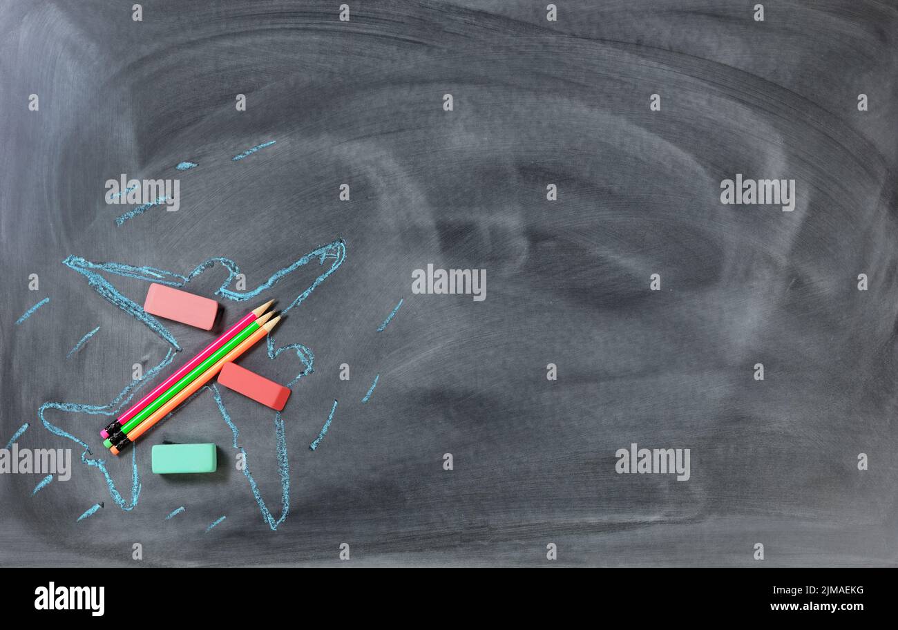 Back to school with flying airplane drawing and supplies on chalkboard ...