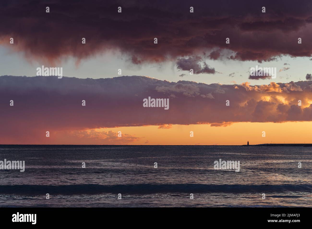 Dramatic colorful clouds at sunset hovering over the sea Stock Photo ...