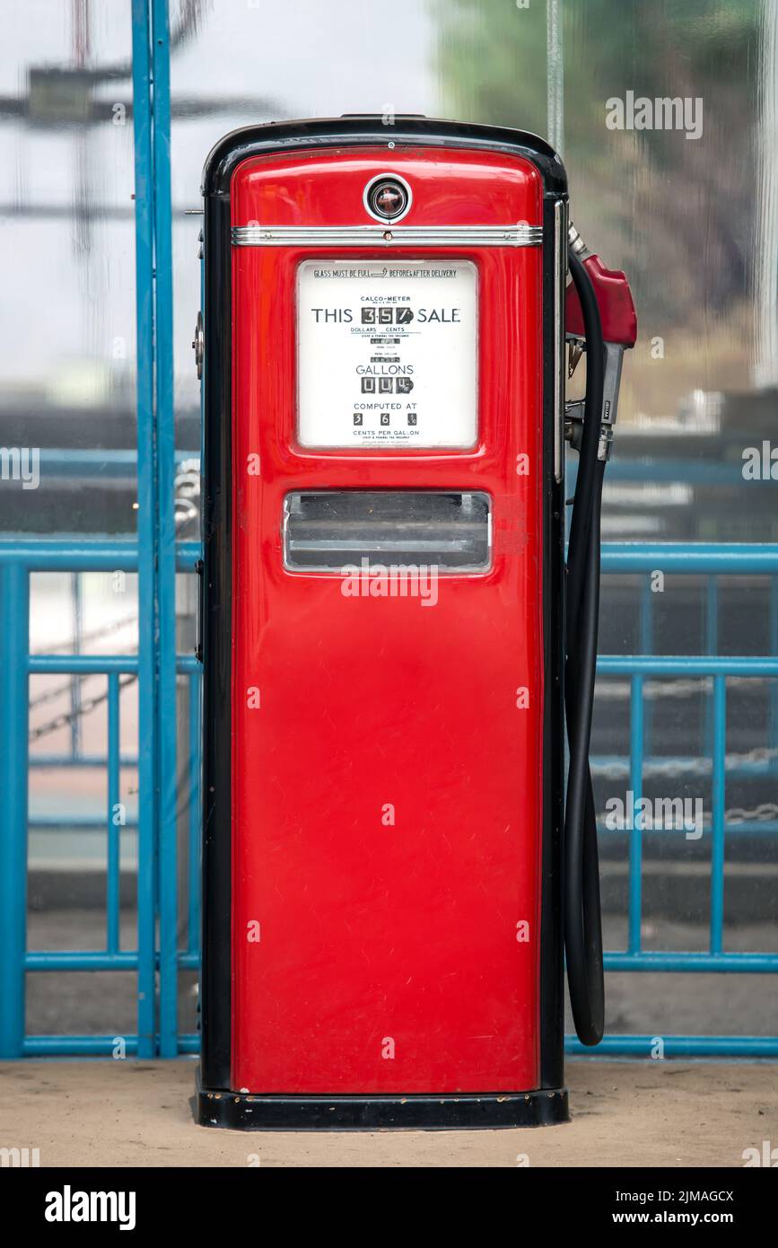 Ancient gas pump painted in black and Bright red in the setting of an ...