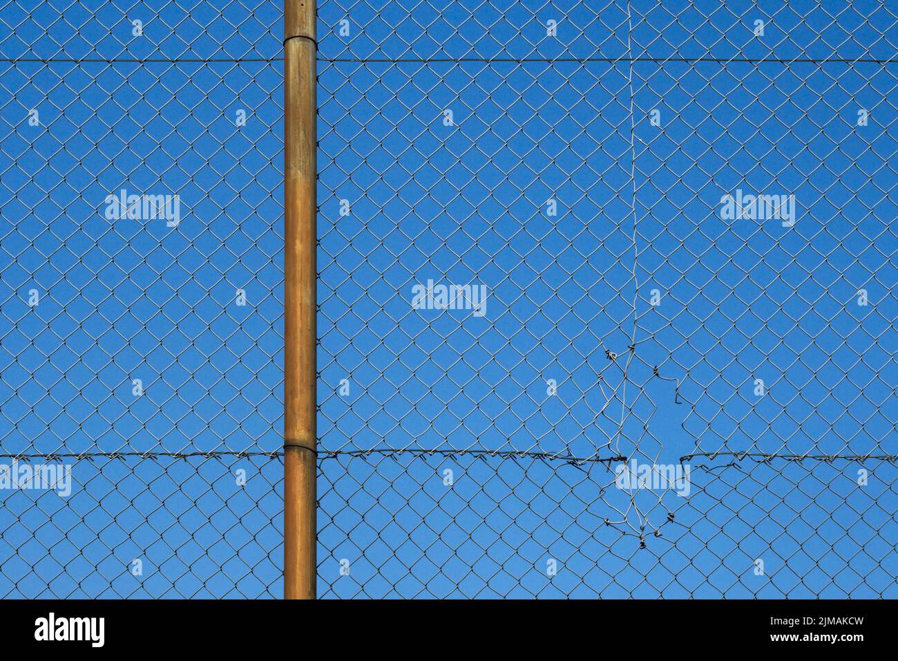 Wire mesh fence with hole Stock Photo - Alamy