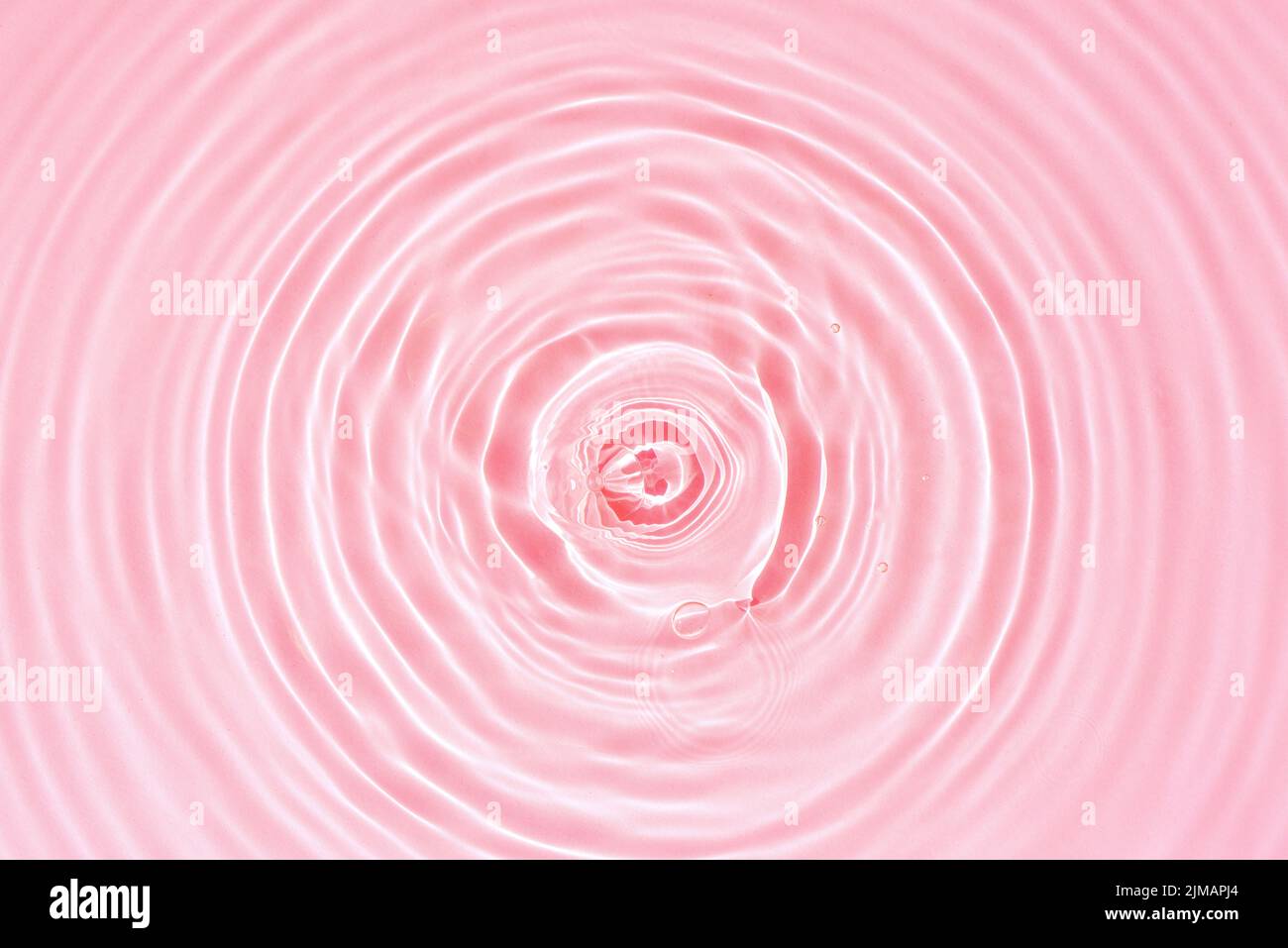 Cosmetic pink water background, texture water with rings and ripples ...