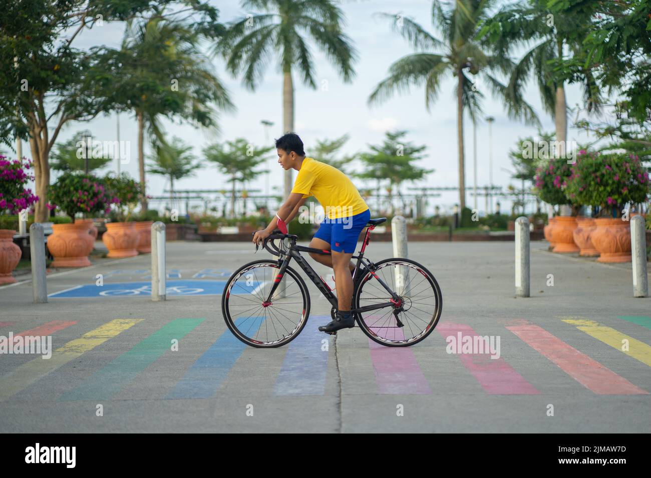An athletic man on a bicycle at a coastal park in Alaminos City ...