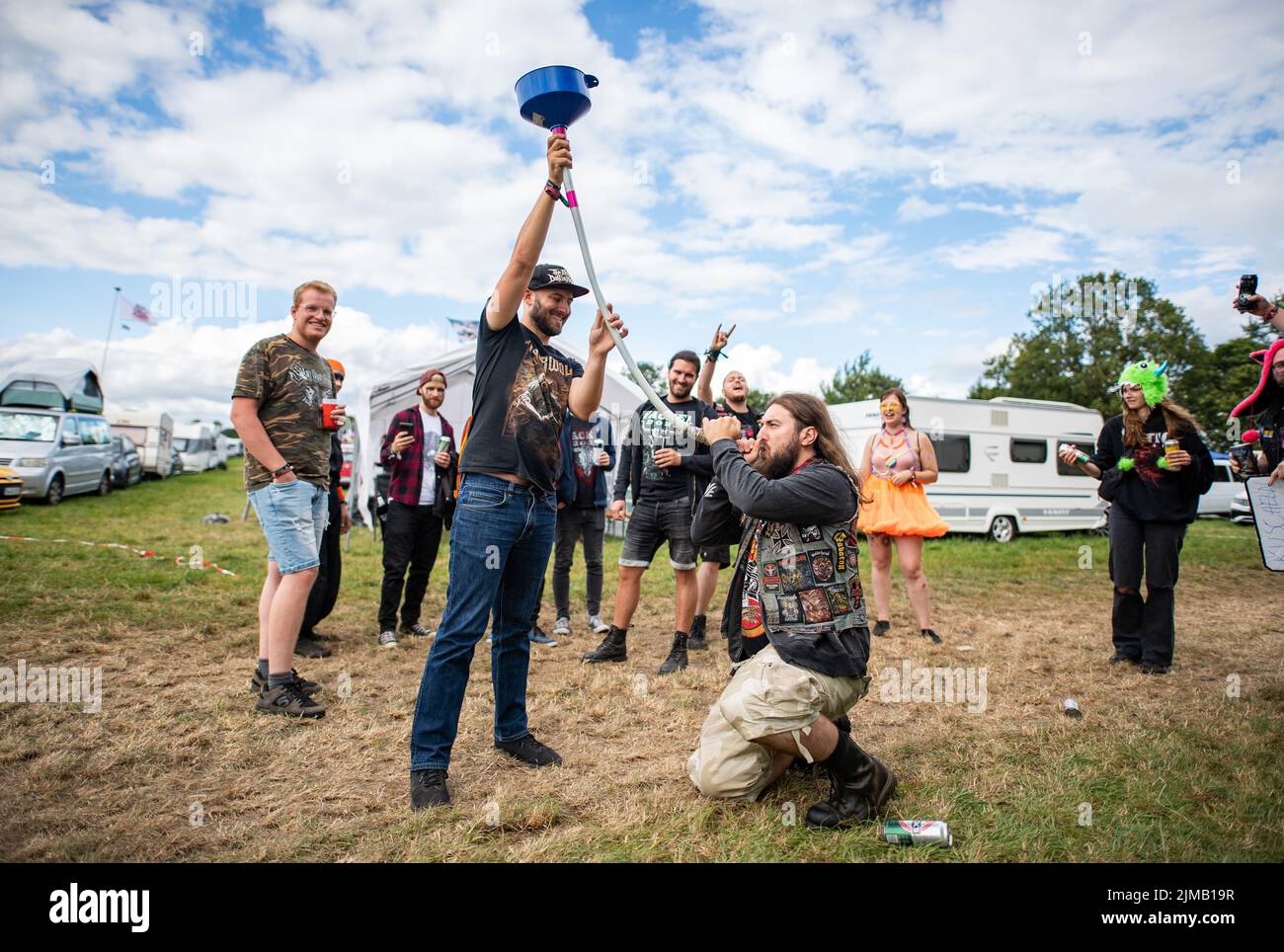 Wacken, Germany. 05th Aug, 2022. A man drinks beer from a hose at the ...