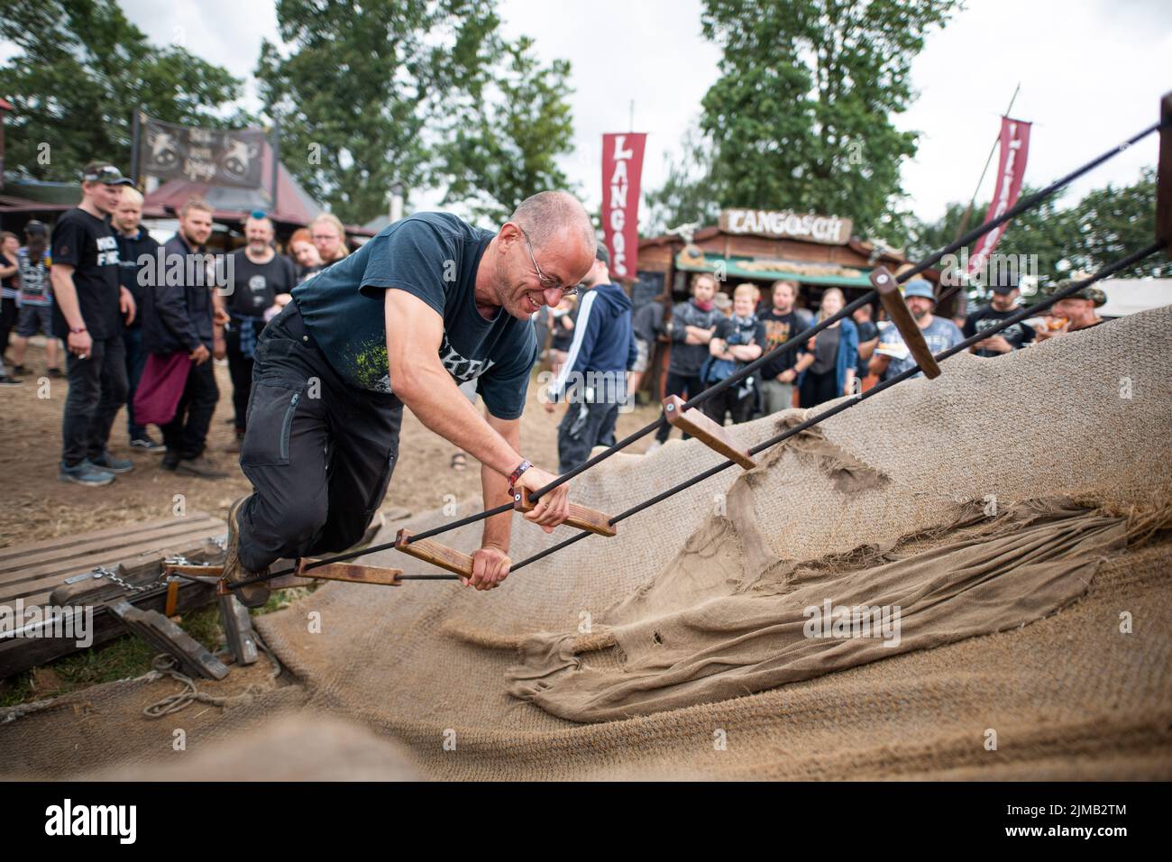 Wacken, Germany. 05th Aug, 2022. A man climbs along a rickety ladder at ...