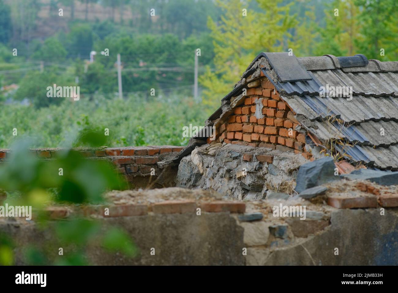 A triangular brick roof against green trees background Stock Photo - Alamy