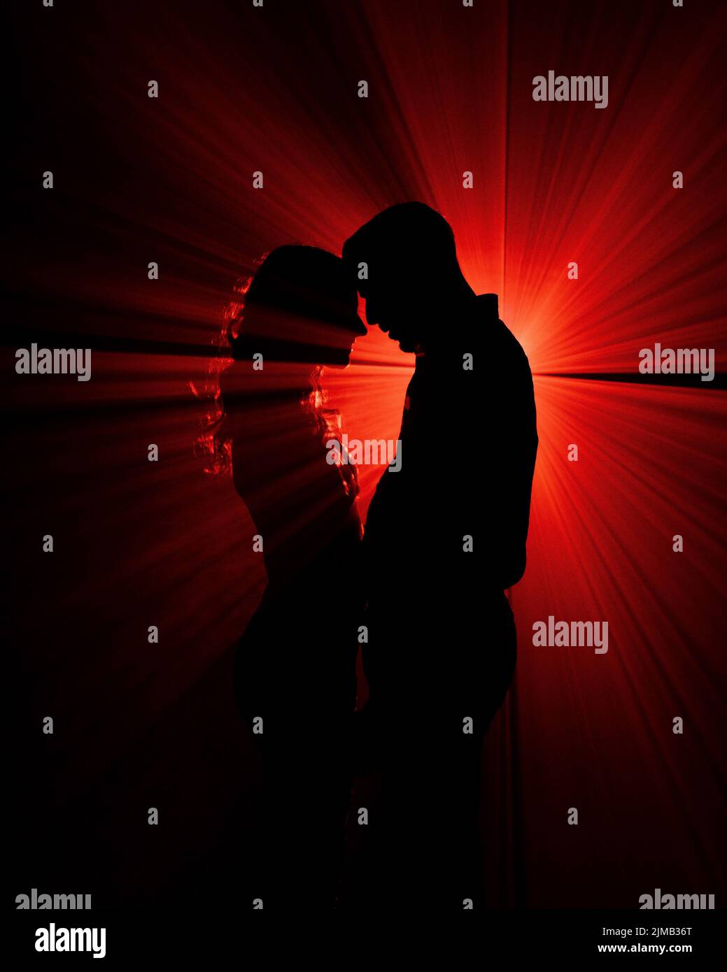 The silhouettes of a beautiful couple with touching foreheads under the ...