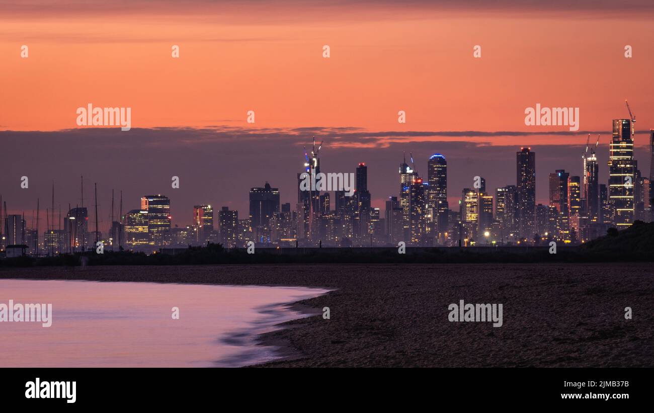 A scenic city skyline at dusk against an orange sky Stock Photo - Alamy