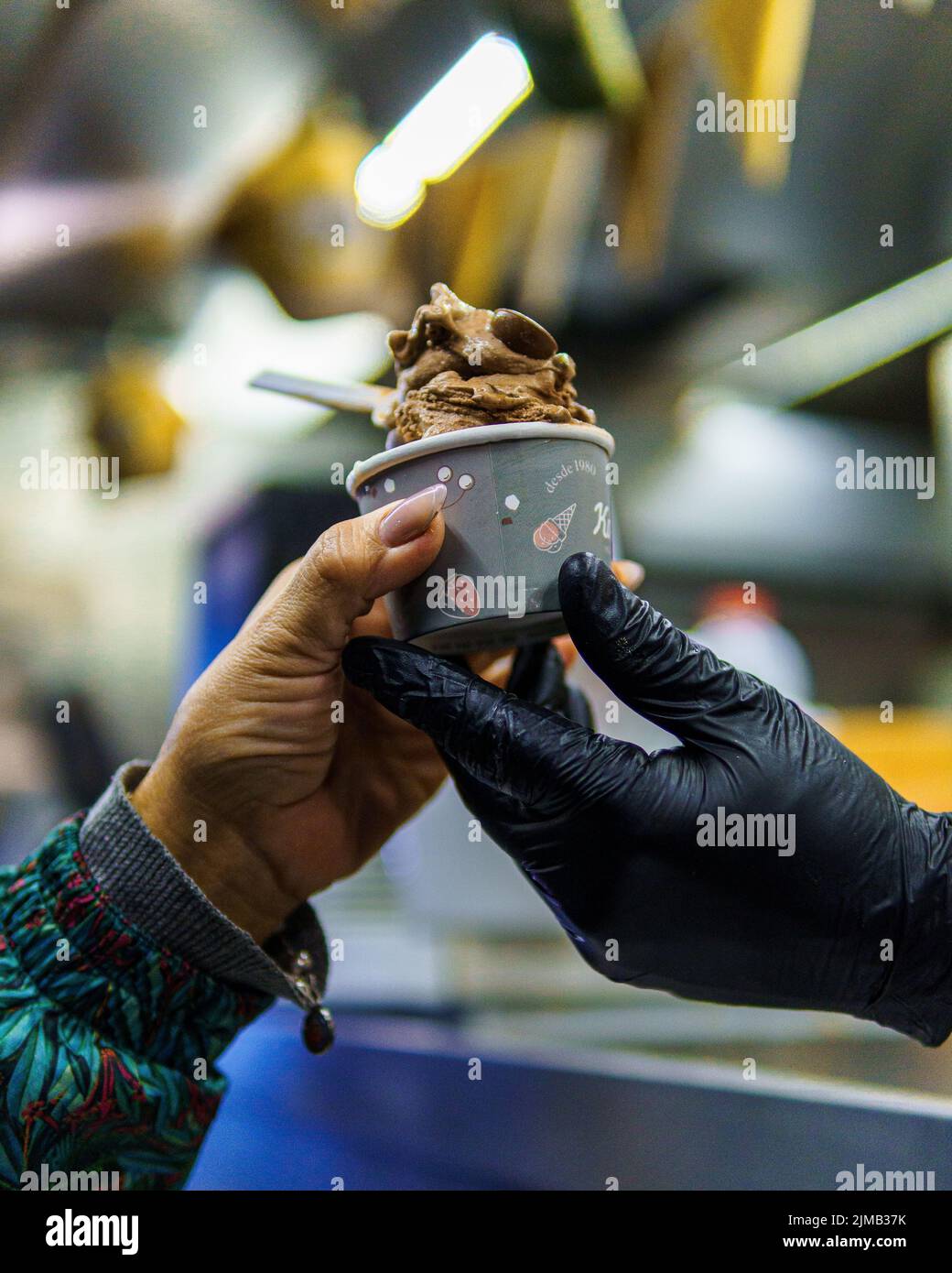 A hand giving chocolate ice cream to a girl Stock Photo - Alamy
