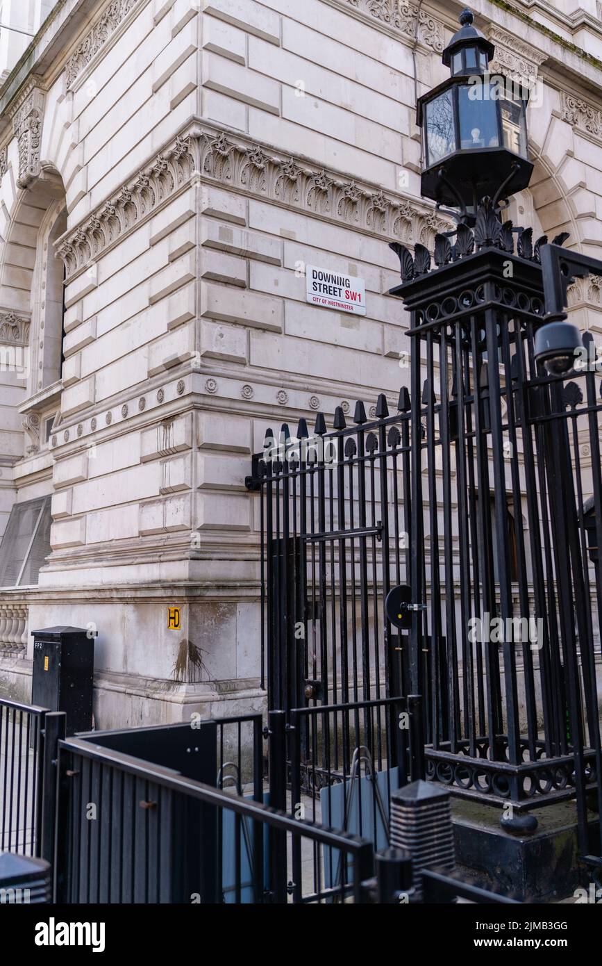 a vertical shot of a road sign on the corner of Downing Street, home to ...