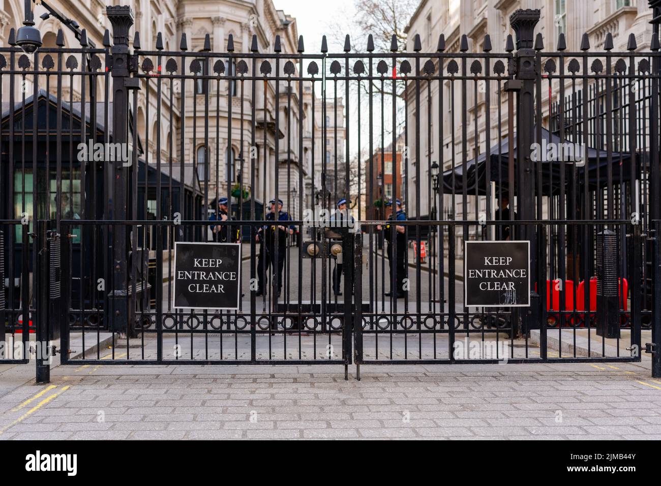 the entrance to Downing Street, black security gates with armed Police ...