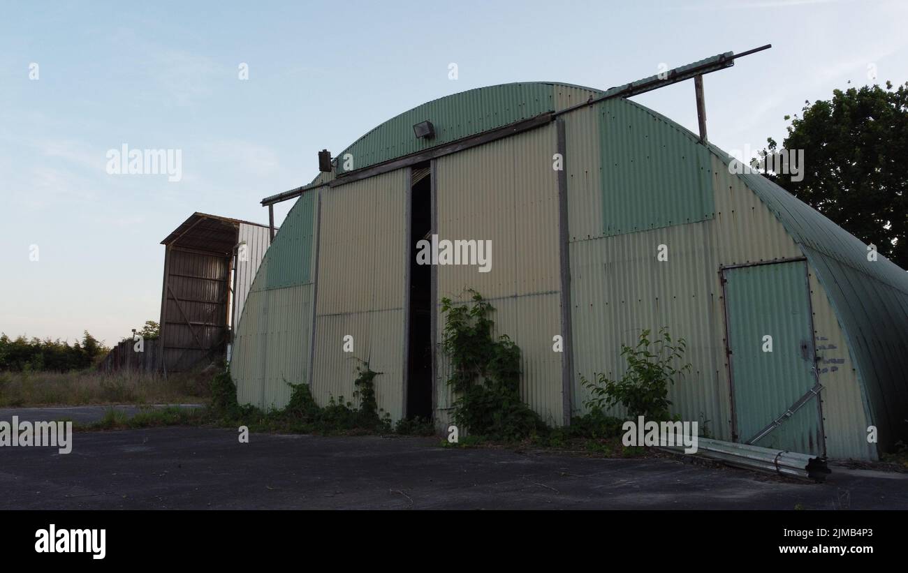 A view of an abandoned factory in a field during sunset Stock Photo - Alamy
